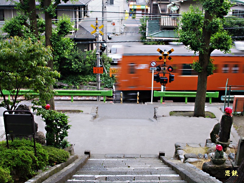 An old type commuter train JE-E Class 201 EMU passes a railroad crossing.